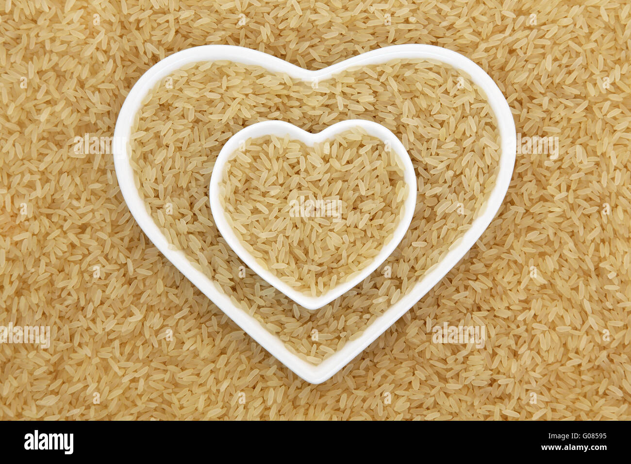Long grain brown rice in heart shaped porcelain dishes forming an ...