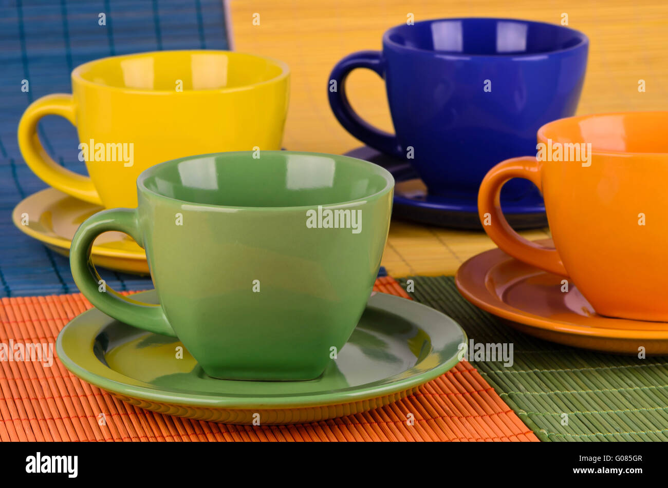 A set of colorful cups with plates Stock Photo - Alamy