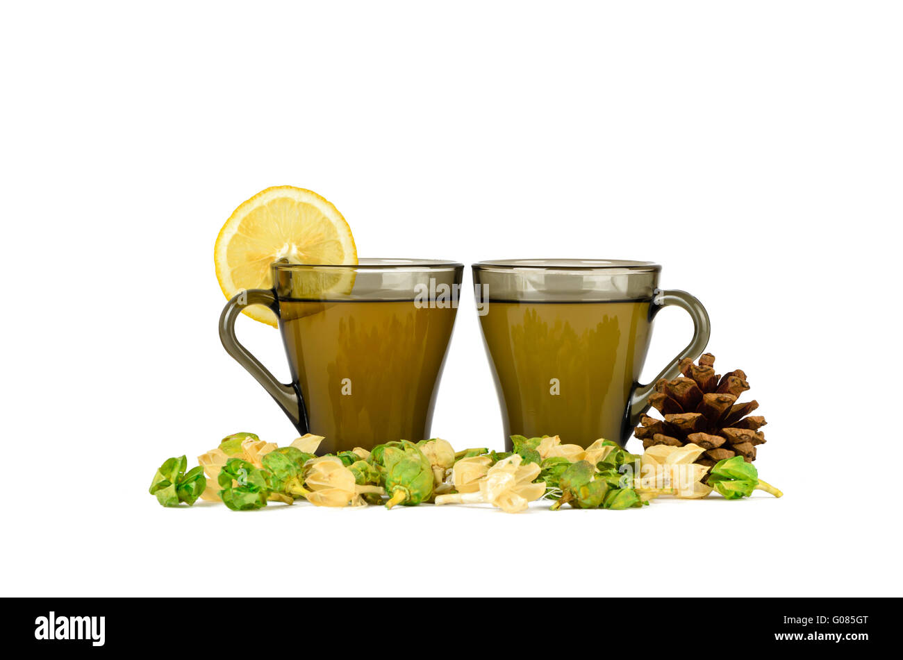 Two cups of green tea with lemon, fir-cone and phy Stock Photo - Alamy