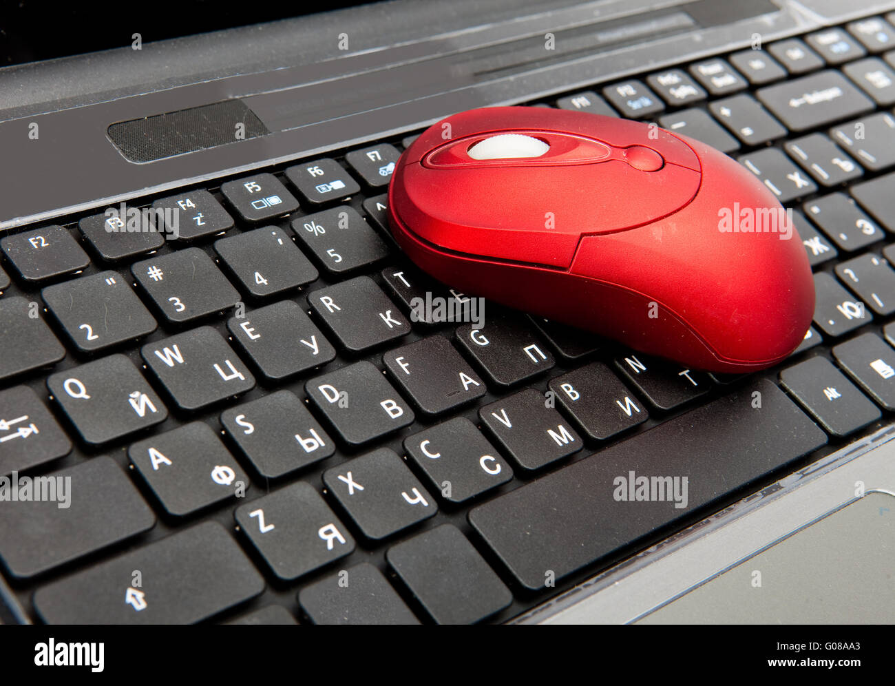 The red computer mouse on the black keyboard Stock Photo - Alamy