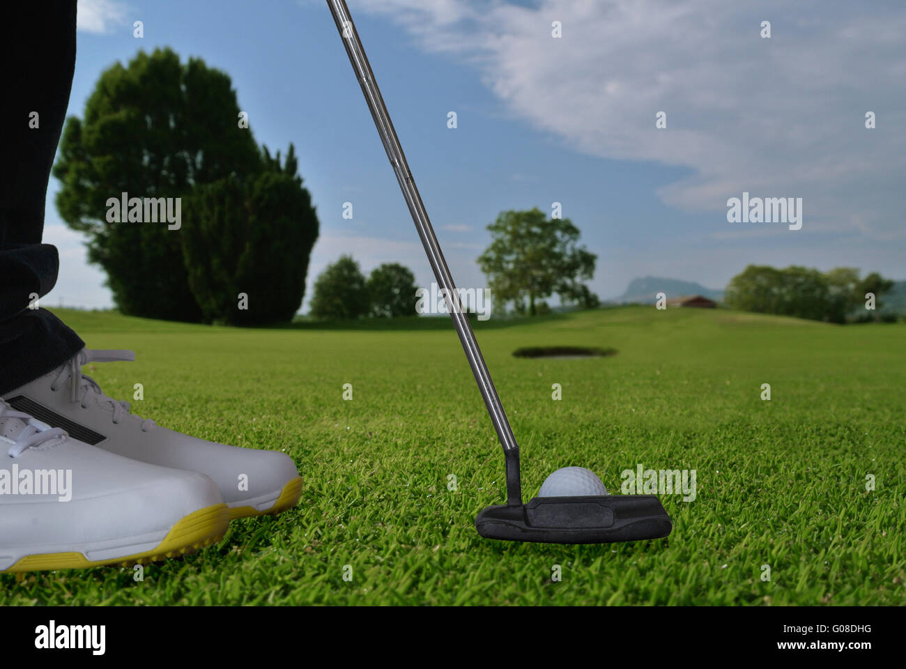 golf hole and ball and a man with putter Stock Photo - Alamy