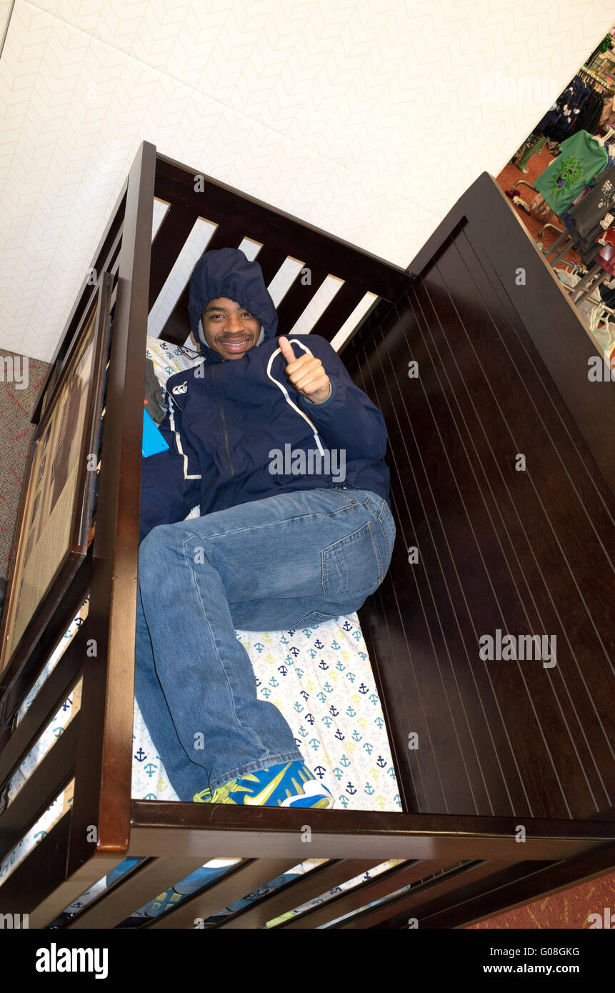 Proud black man age 23 testing comfort of crib for his new baby in ...