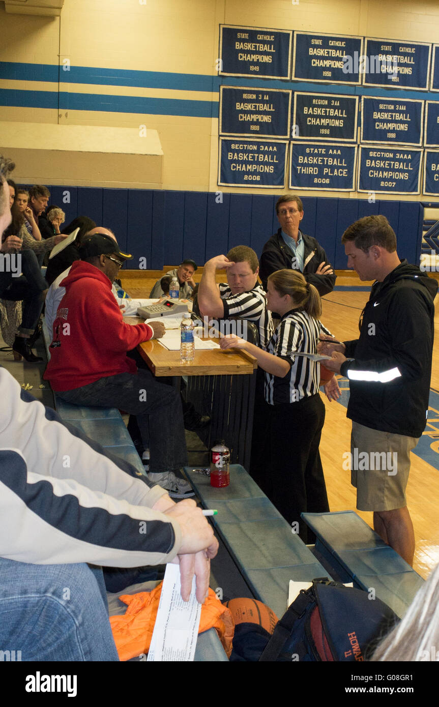 Man and woman basketball referees checking in at the timer and score ...