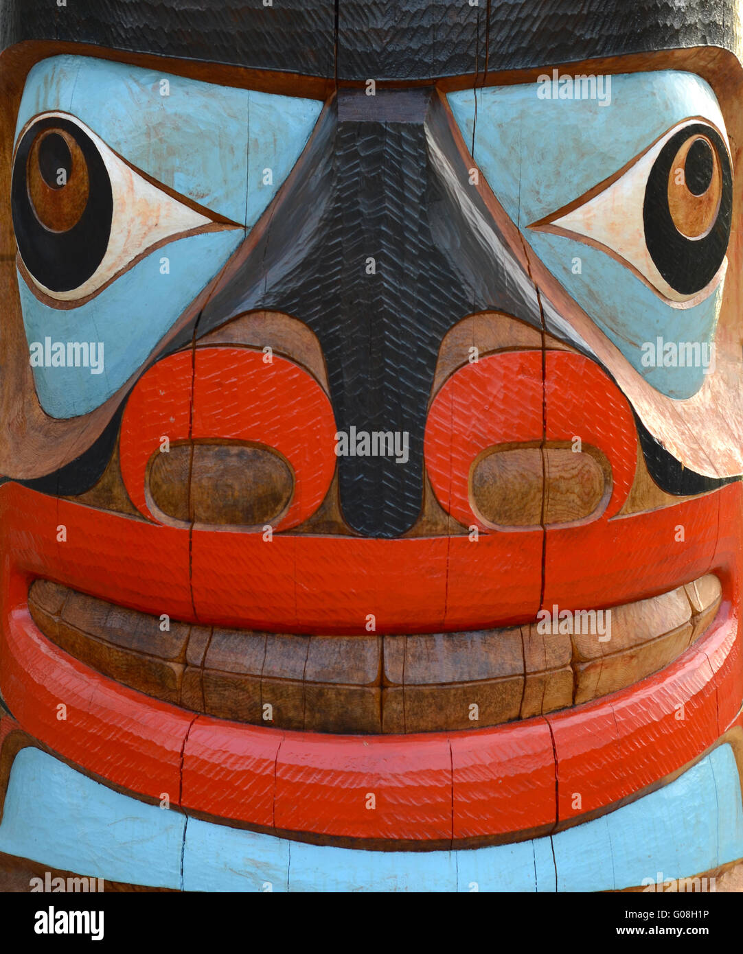 Detail Of A Brightly Painted Face On A Totem Pole Stock Photo - Alamy
