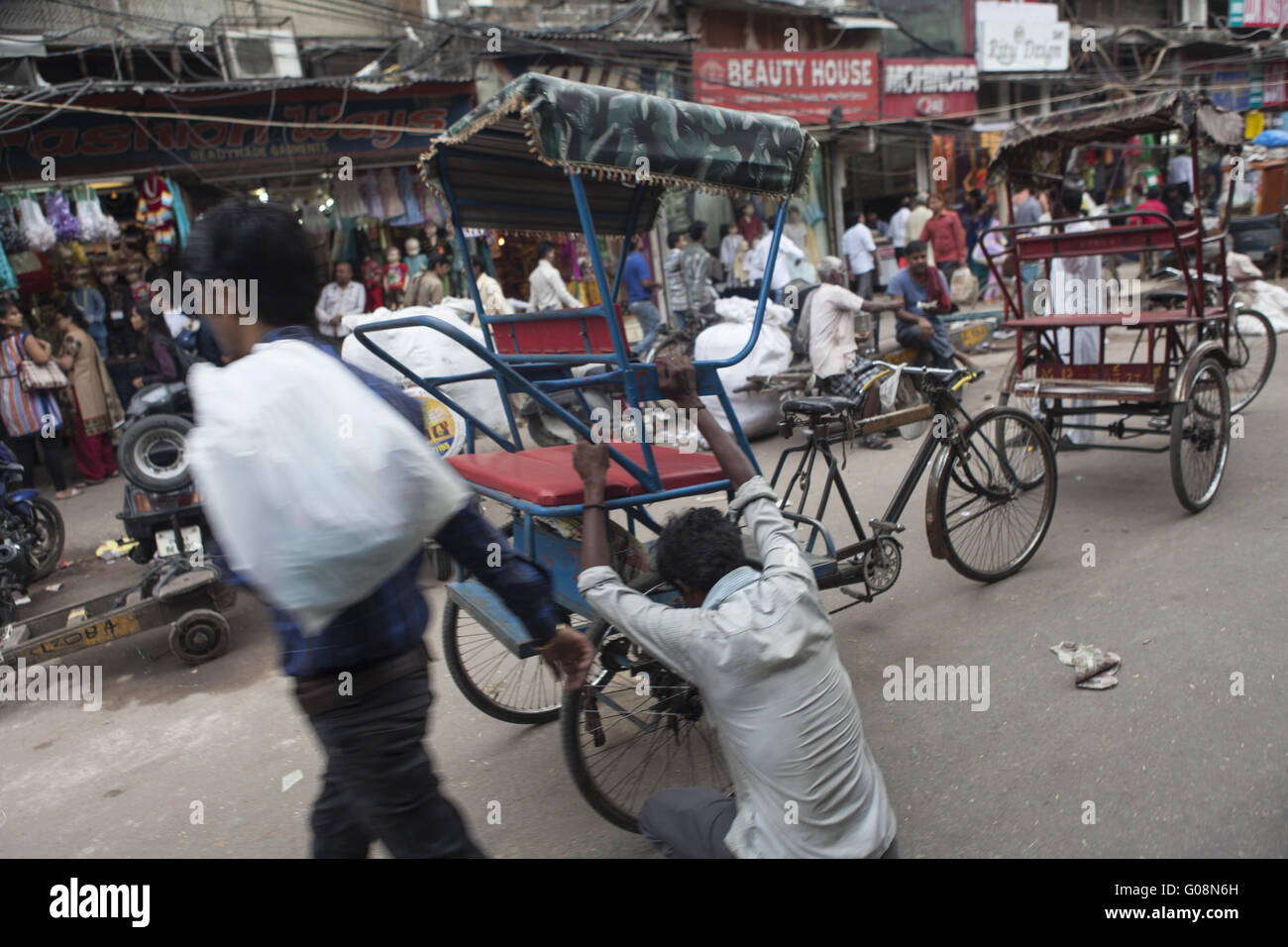 Rickshaw driver crouched down, Old-Dehli, India Stock Photo - Alamy