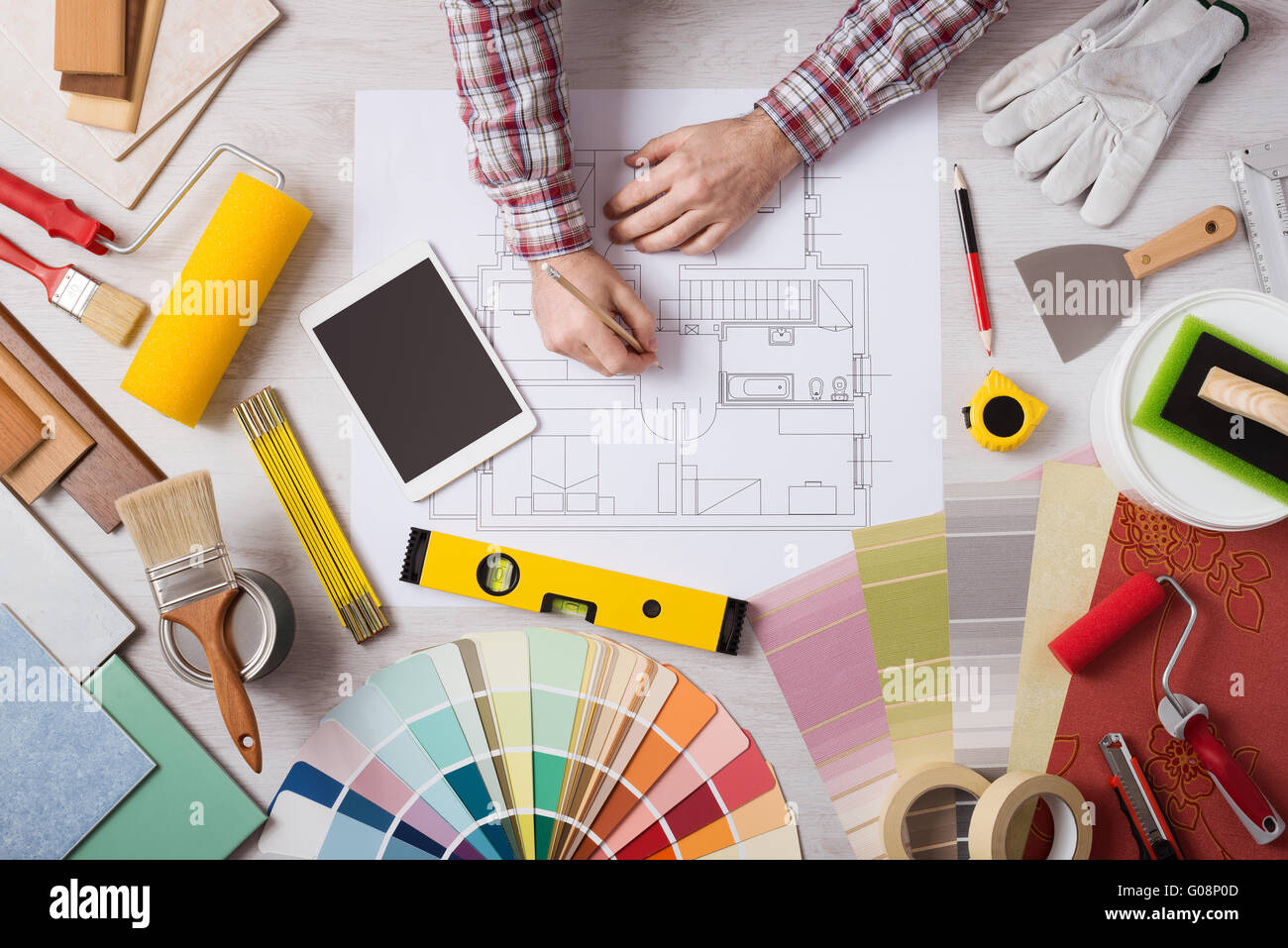 Professional decorator drawing on a house project with work tools ...