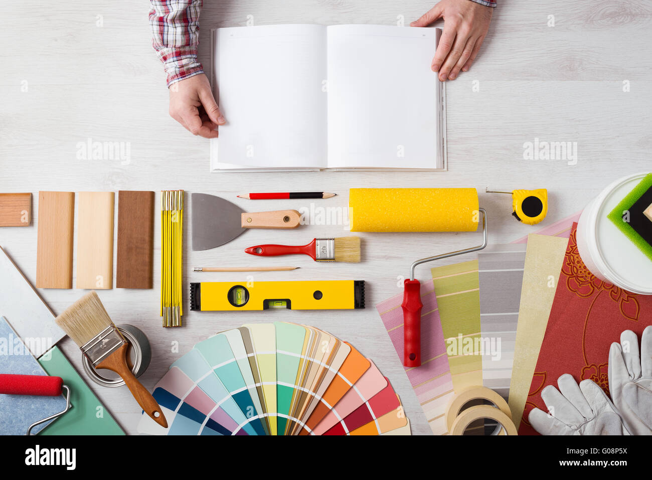 Hands holding DIY training open manual with work tools, color swatches ...