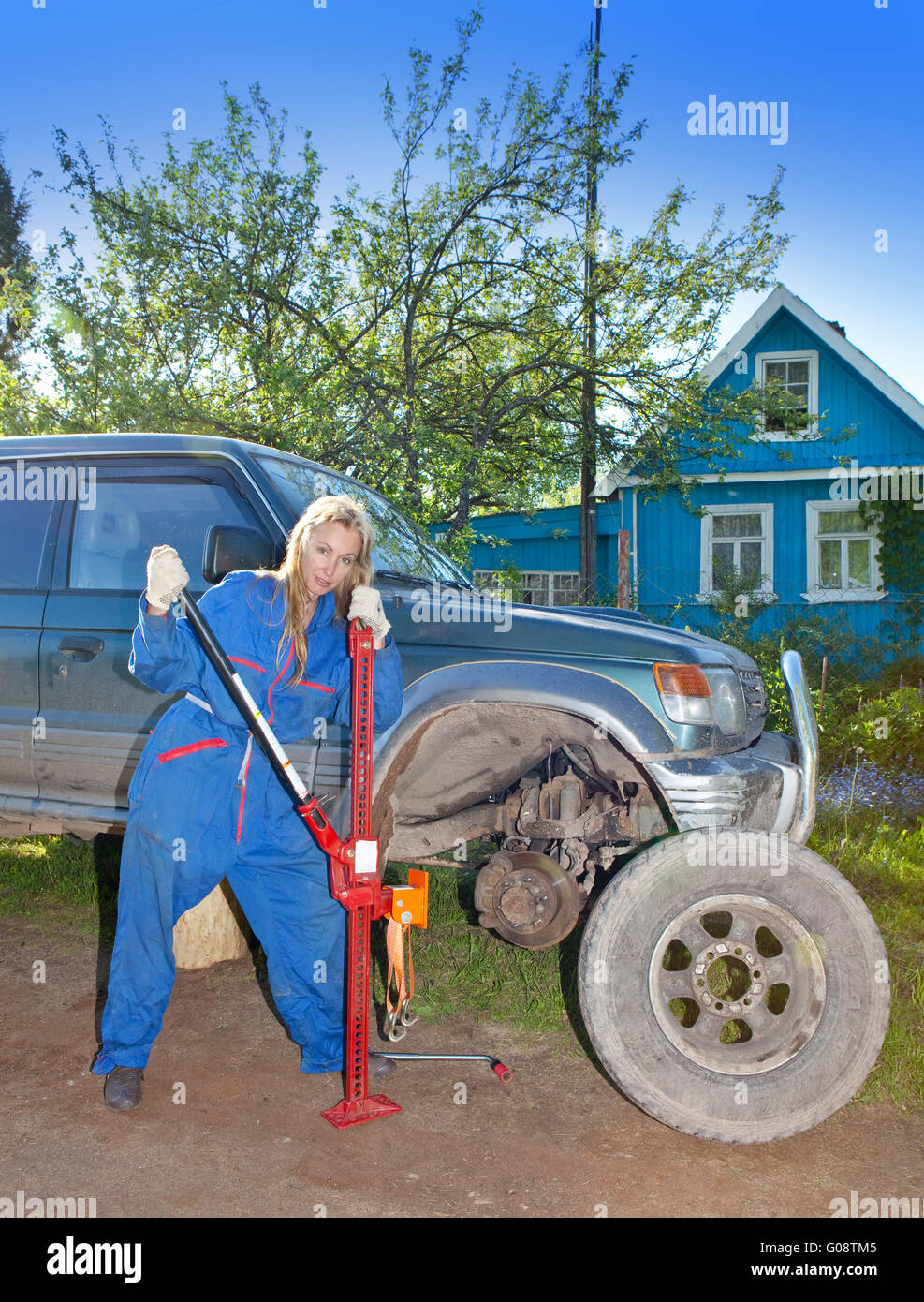 The woman in working overalls tries to replace a w Stock Photo - Alamy
