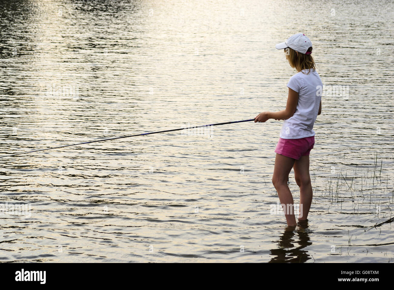 Girl fishing in a lake Stock Photo - Alamy