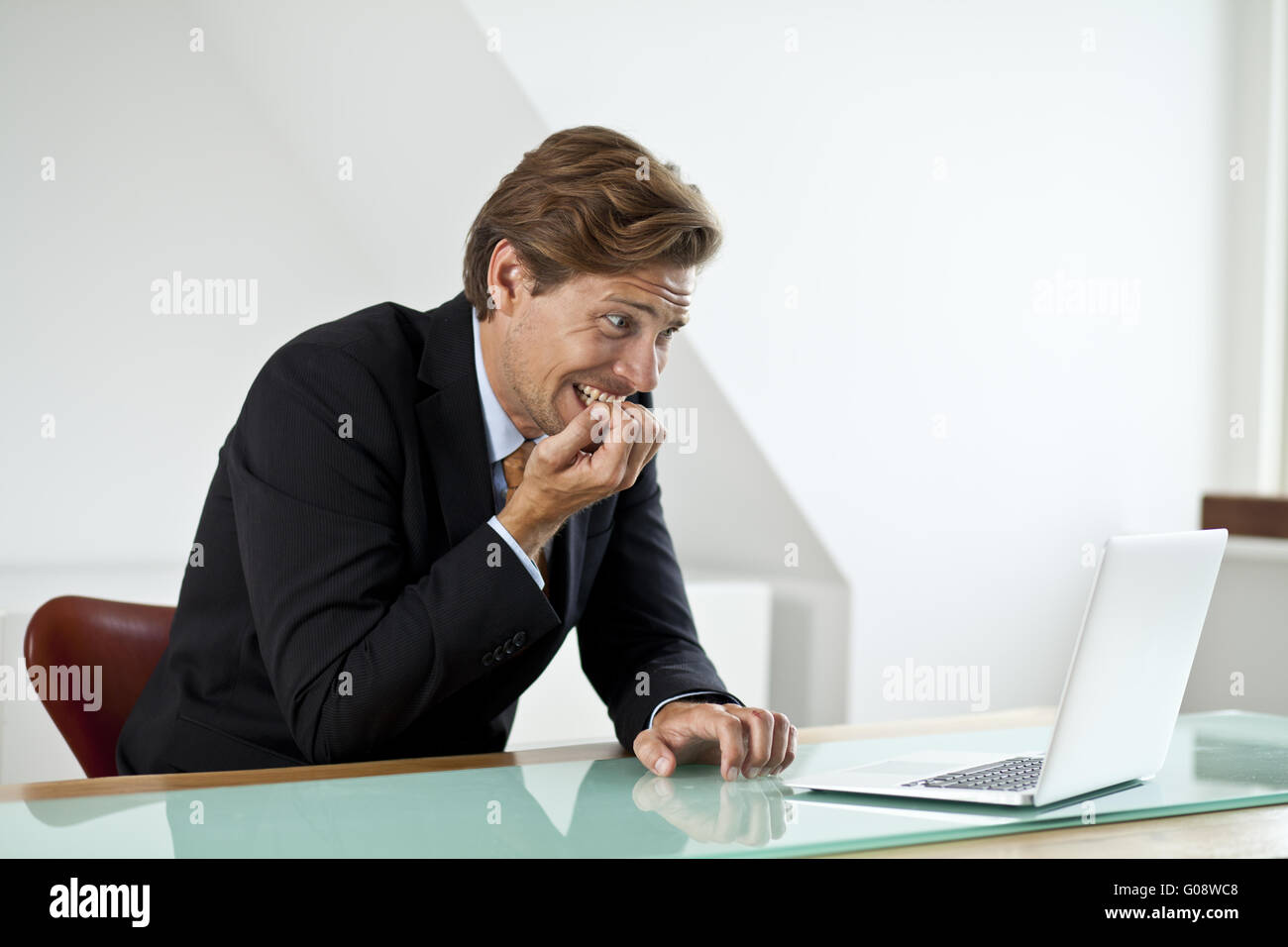 Anxious businessman looking at laptop Stock Photo - Alamy