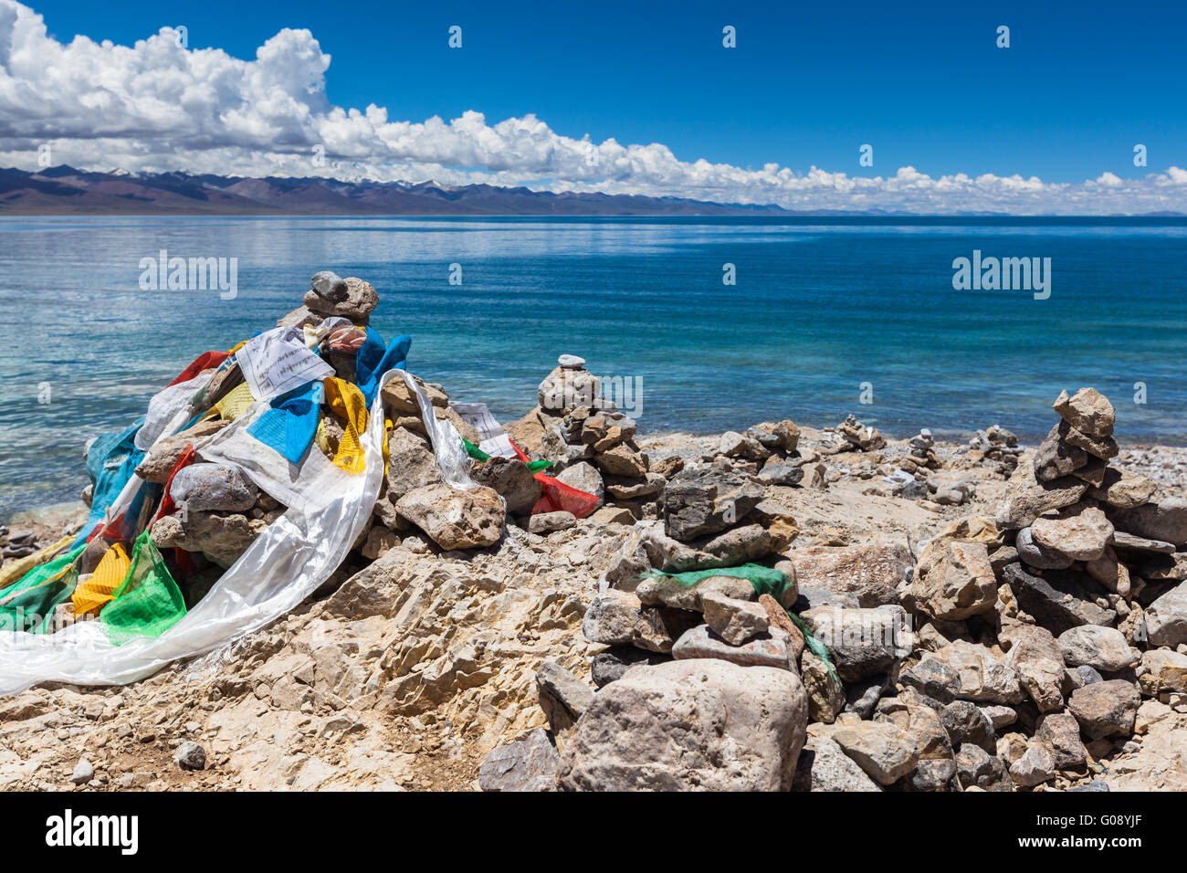 Marnyi stone with sutra streamers on the lakeside of Namtso, Tibet ...