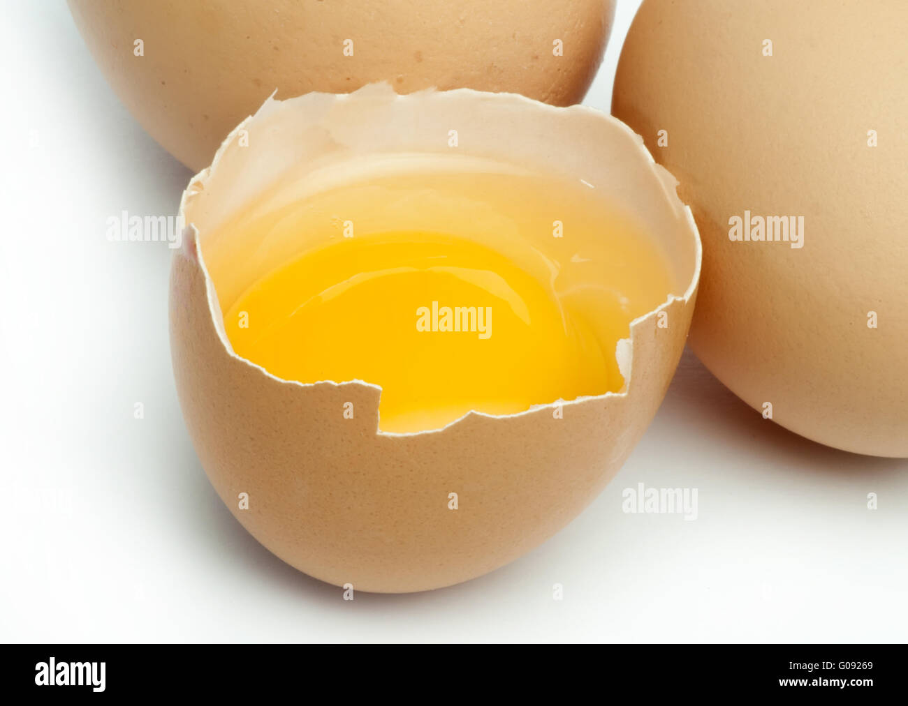 Tree whole eggs and another broken in half raw egg Stock Photo - Alamy