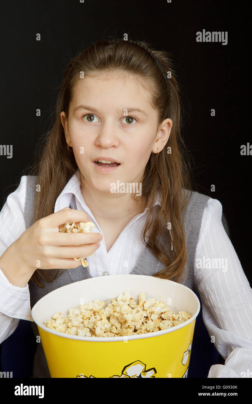 surprised girl with popcorn on a black background Stock Photo - Alamy