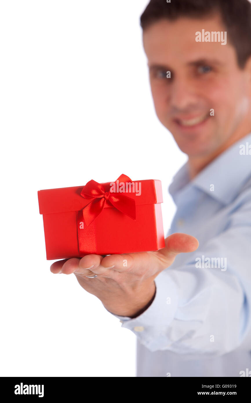 Smiling man offering a gift in a red box and bow Stock Photo - Alamy