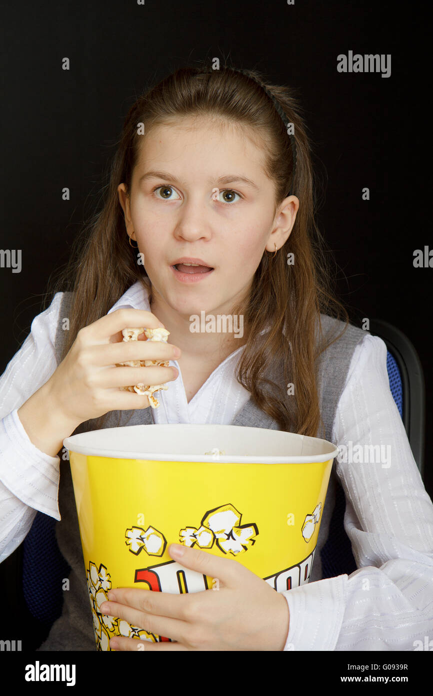 surprised girl with popcorn on a black background Stock Photo - Alamy