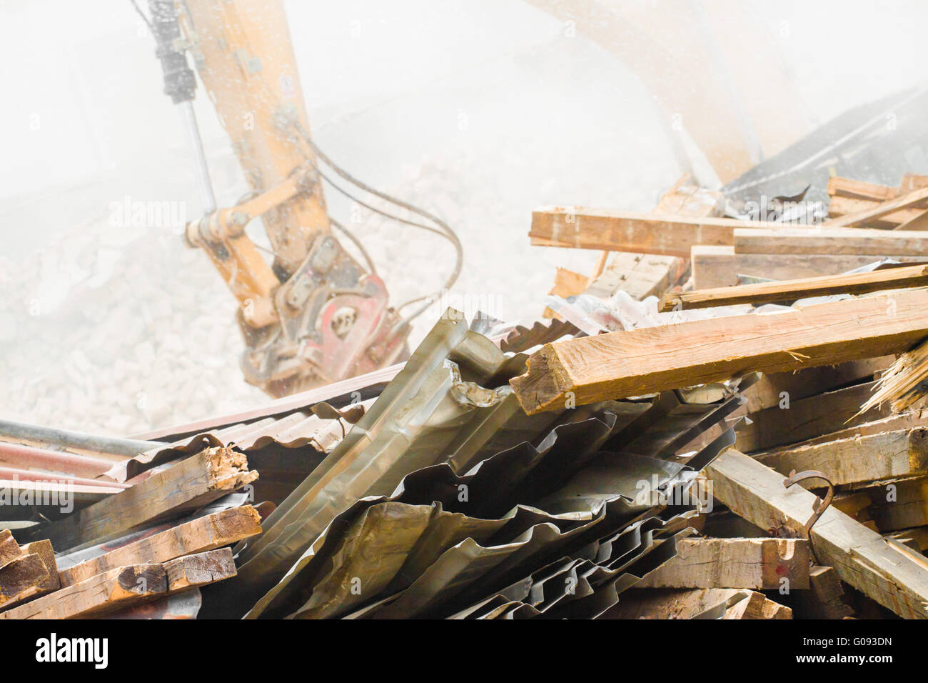 Demolition industry machine taking down walls of old factory building ...