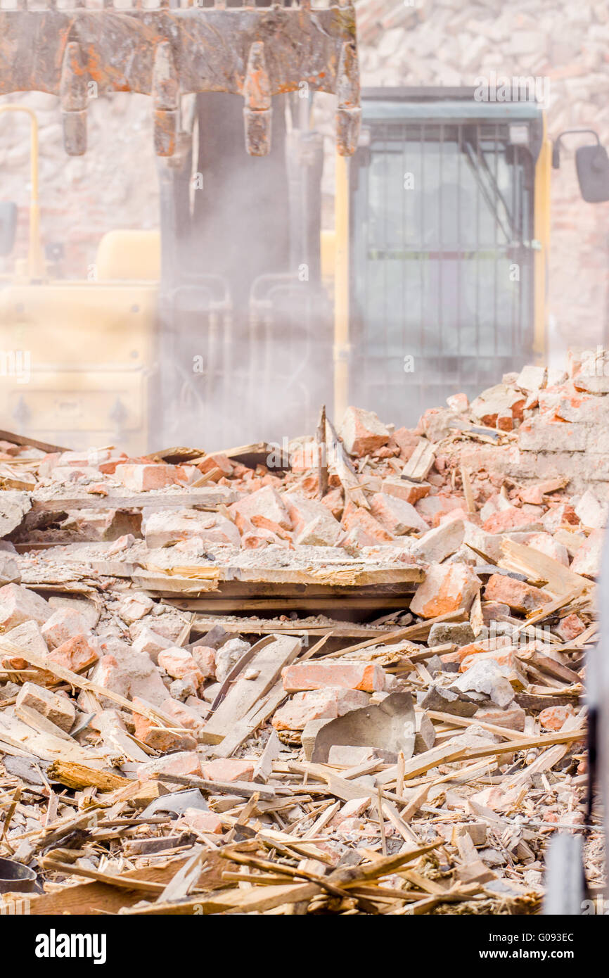 Demolition industry machine taking down walls of old factory building ...