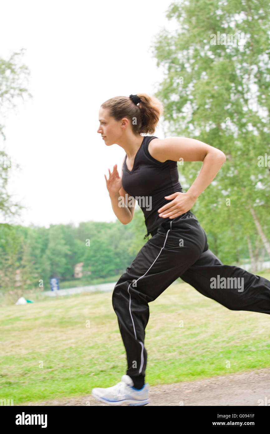 Sportive young woman running over a forrest road Stock Photo - Alamy