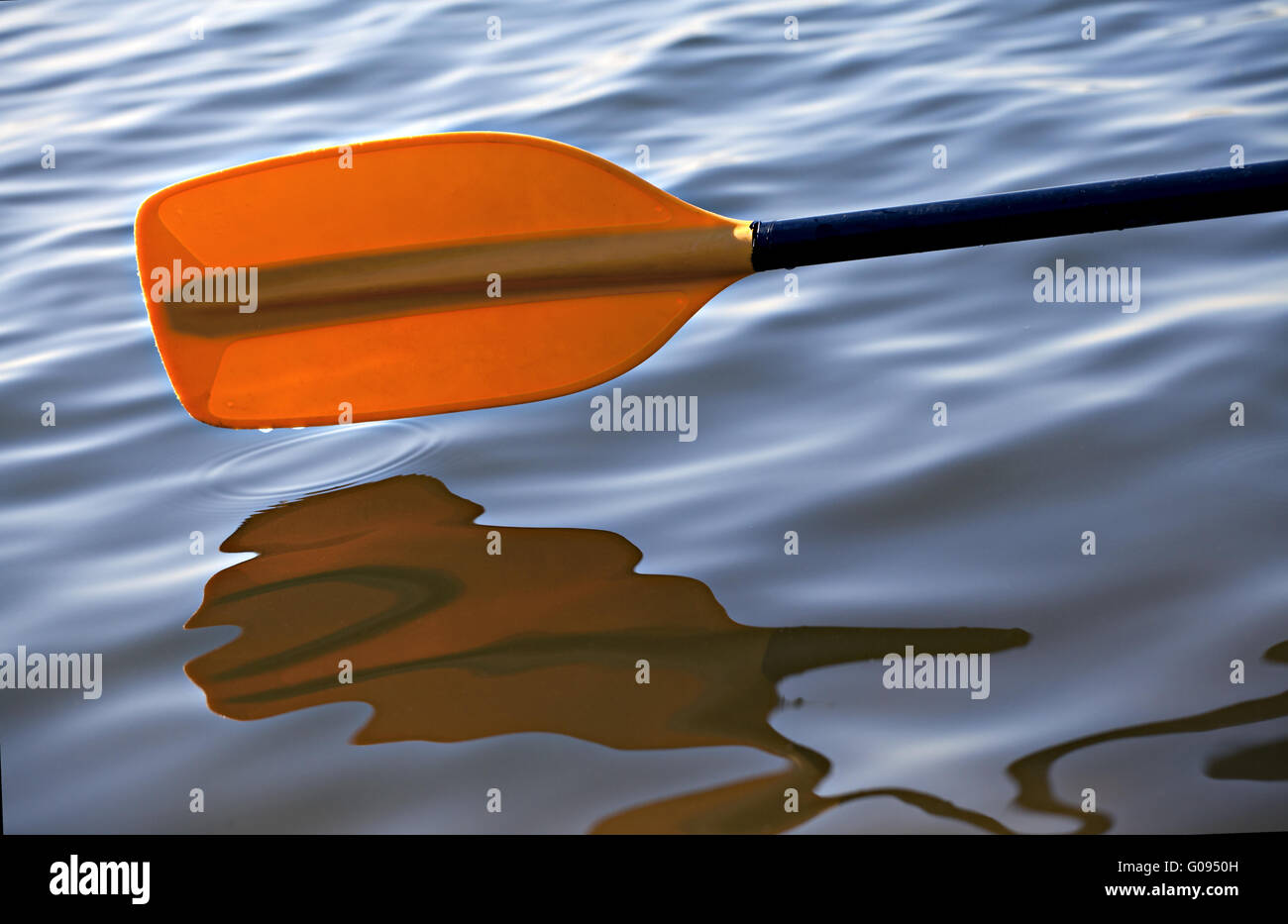 Kayak paddle on side of a boat at still river water Stock Photo - Alamy