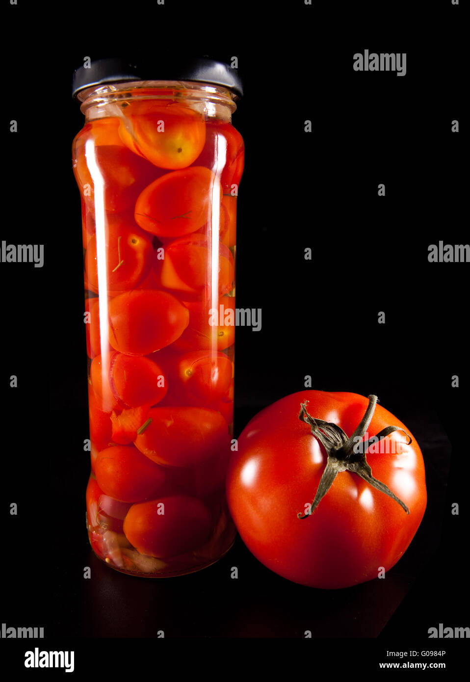 canned tomatoes in glass jar and ripe tomato Stock Photo - Alamy