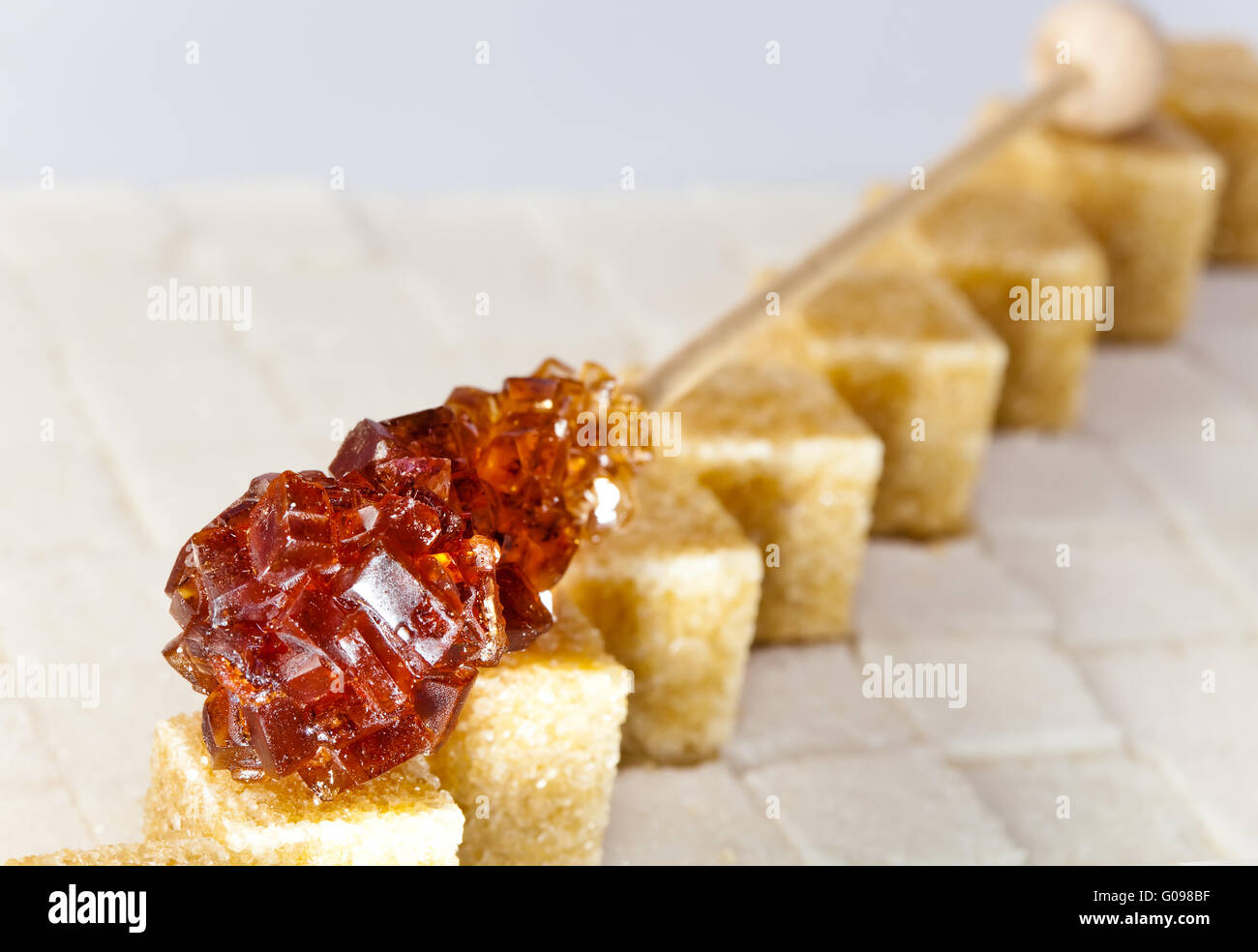 candy brown sugar on a stick lies on lumpy sugar Stock Photo - Alamy