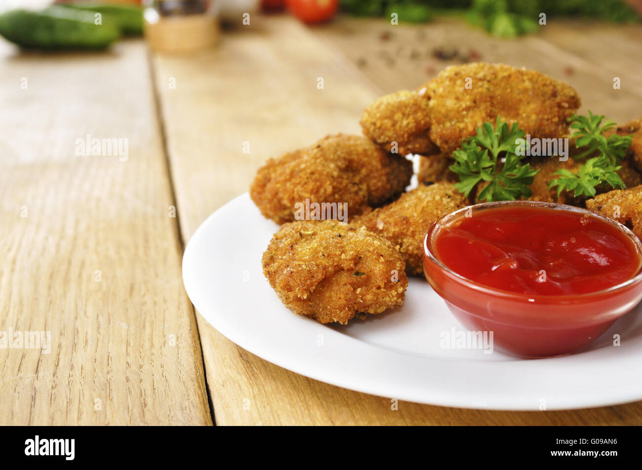 Fried chicken nuggets on the plate on the wooden table Stock Photo - Alamy