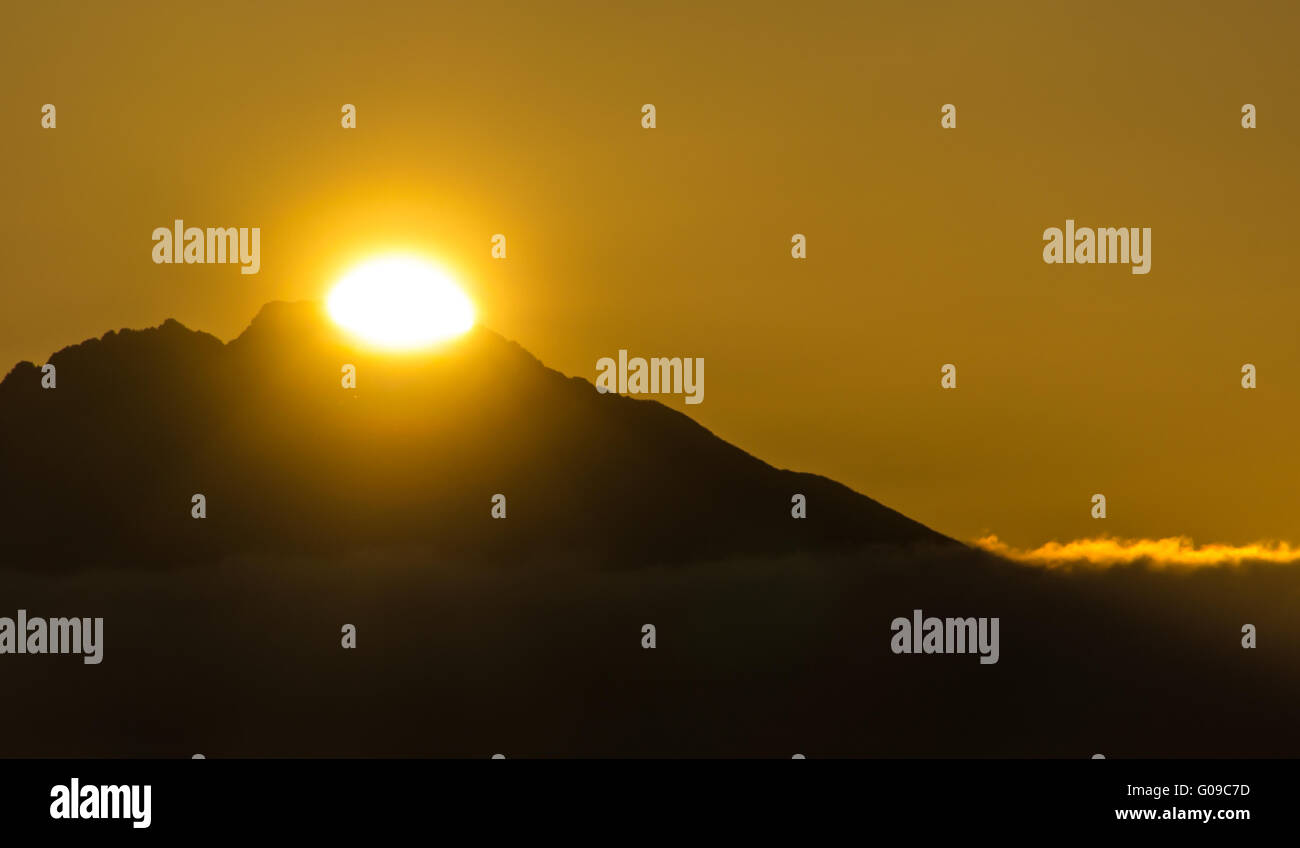 Sun is rising over the mountain Stock Photo - Alamy