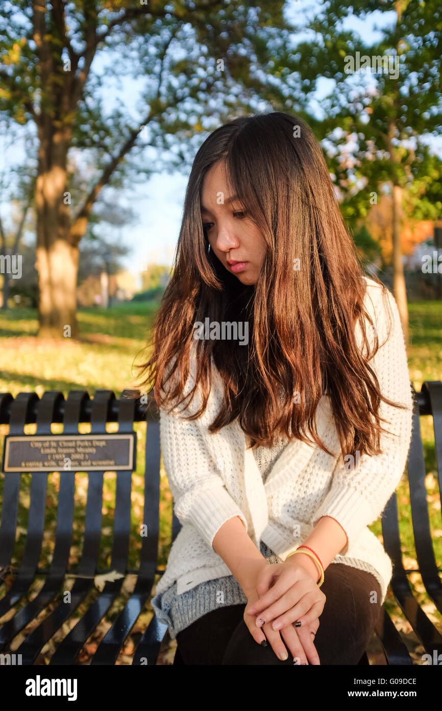 Woman sitting on bench Stock Photo - Alamy