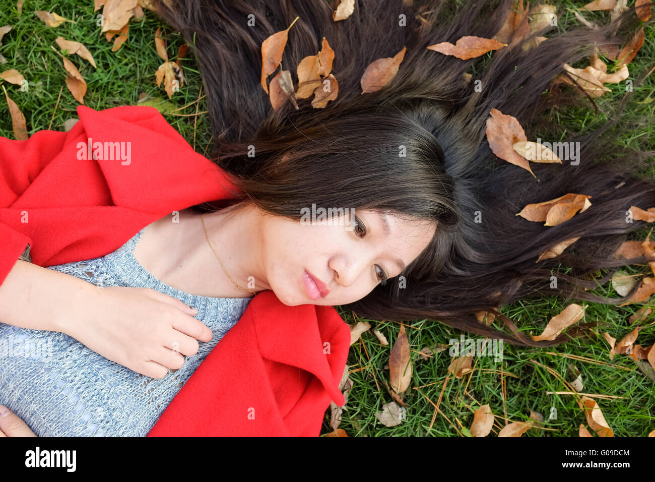 Woman laying on grass Stock Photo - Alamy