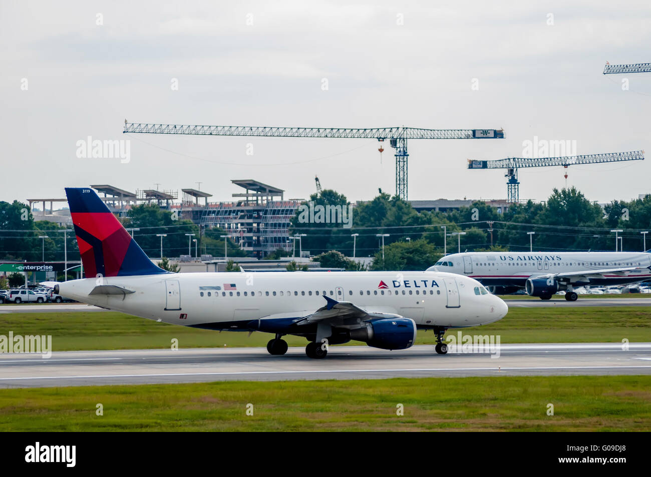 Commercial jet on an airport runway with city skyline in the background ...