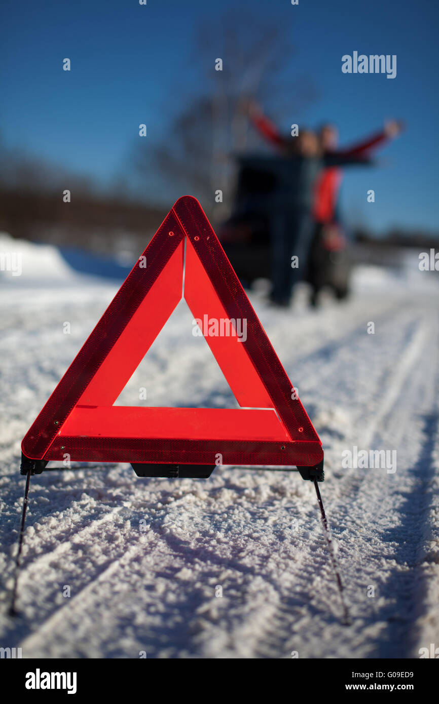 Man And Woman Broken Down On Country Road With Hazard Warning Sign In ...