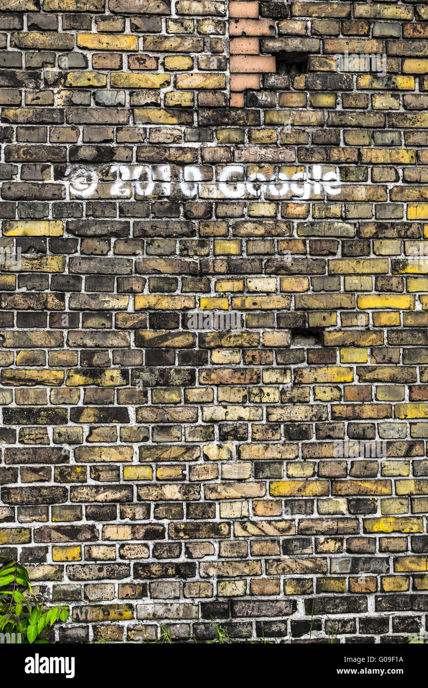 Old brick wall pattern closeup with google graffiti Stock Photo - Alamy