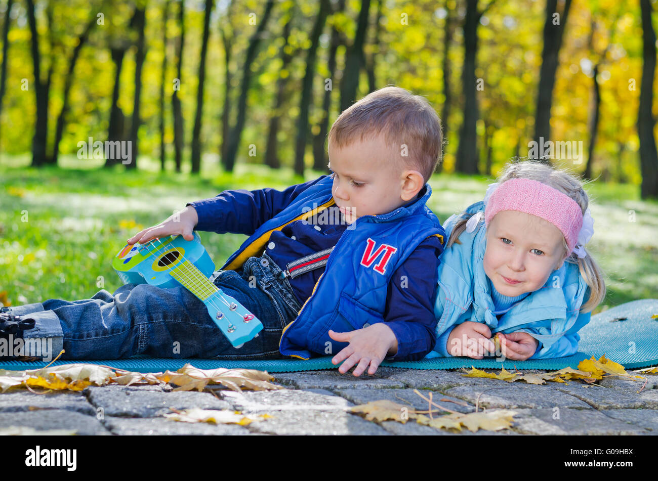 Young Children Laying on the Ground in a Park Stock Photo - Alamy