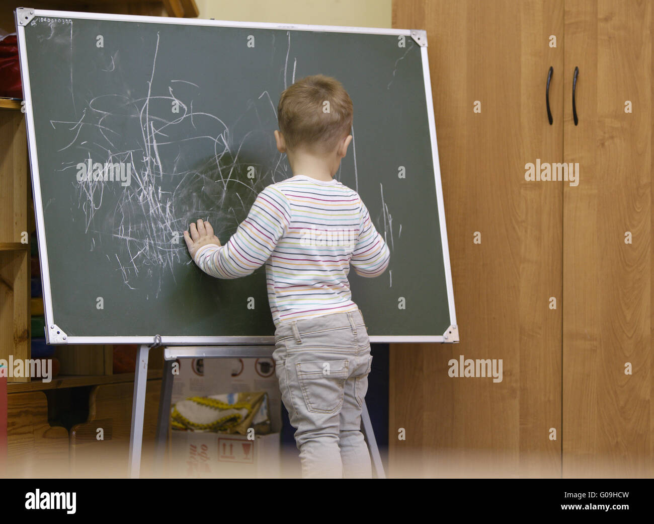 Little boy drawing on a chalkboard at kindergarten Stock Photo - Alamy