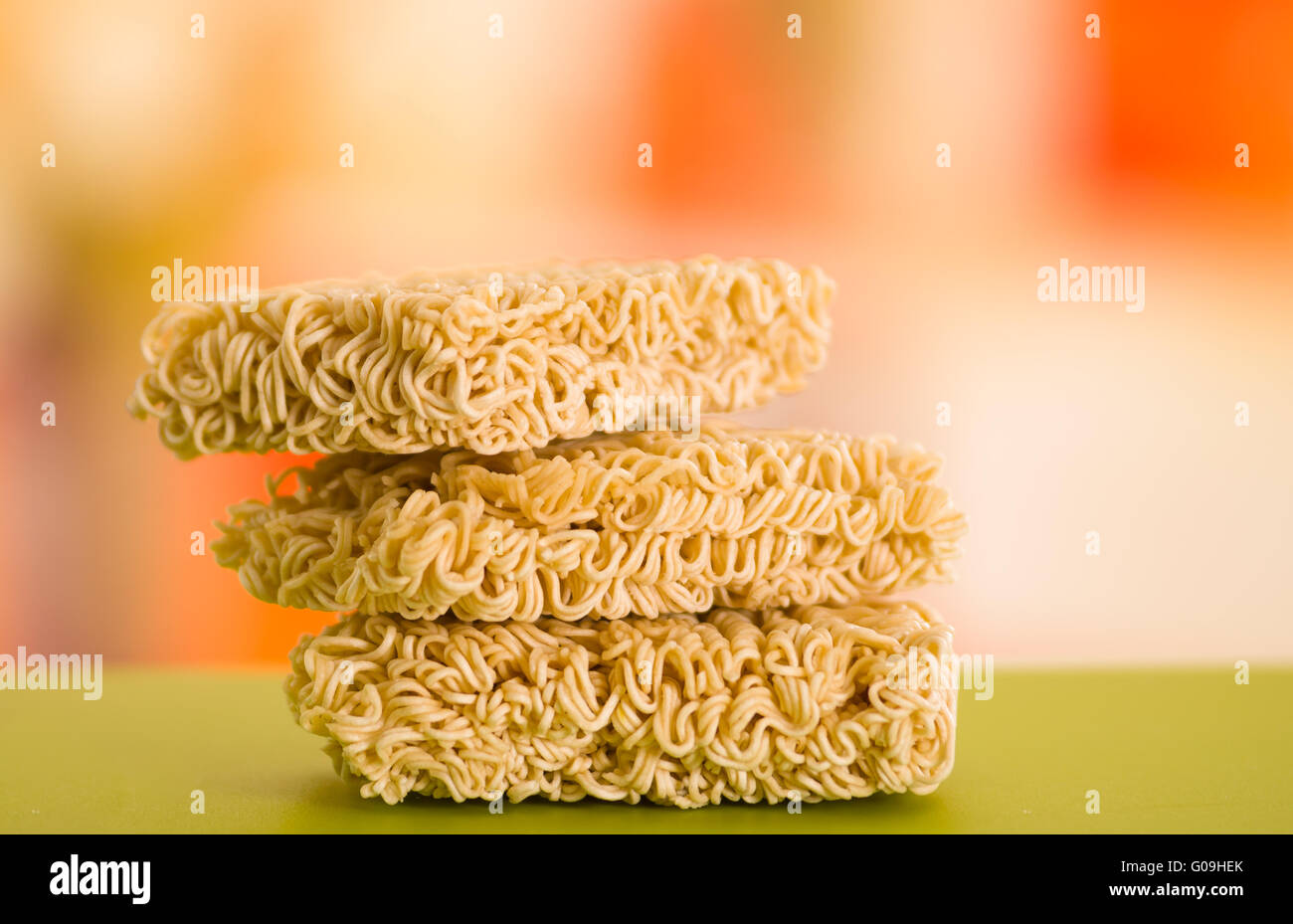 Noodles square blocks stacked on top of each other, green surface and ...
