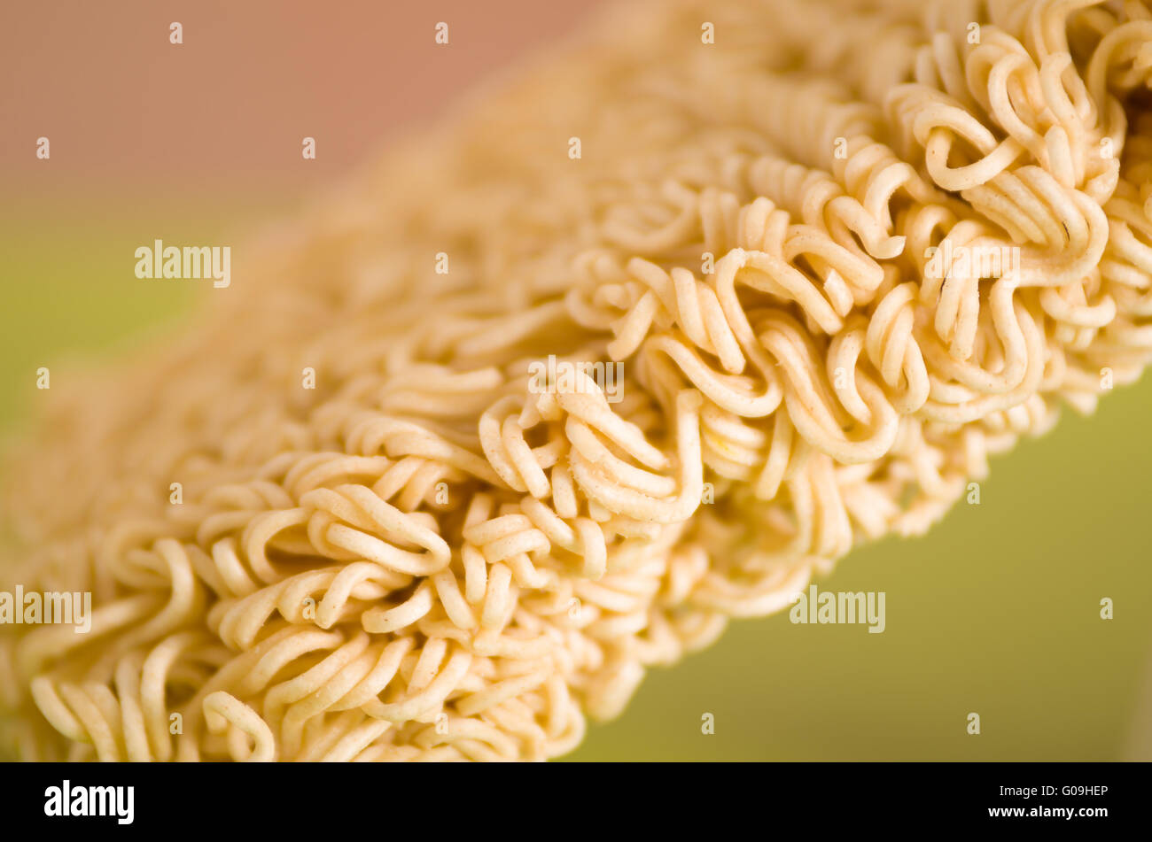 Closeup uncoked noodle block with blurry background Stock Photo - Alamy