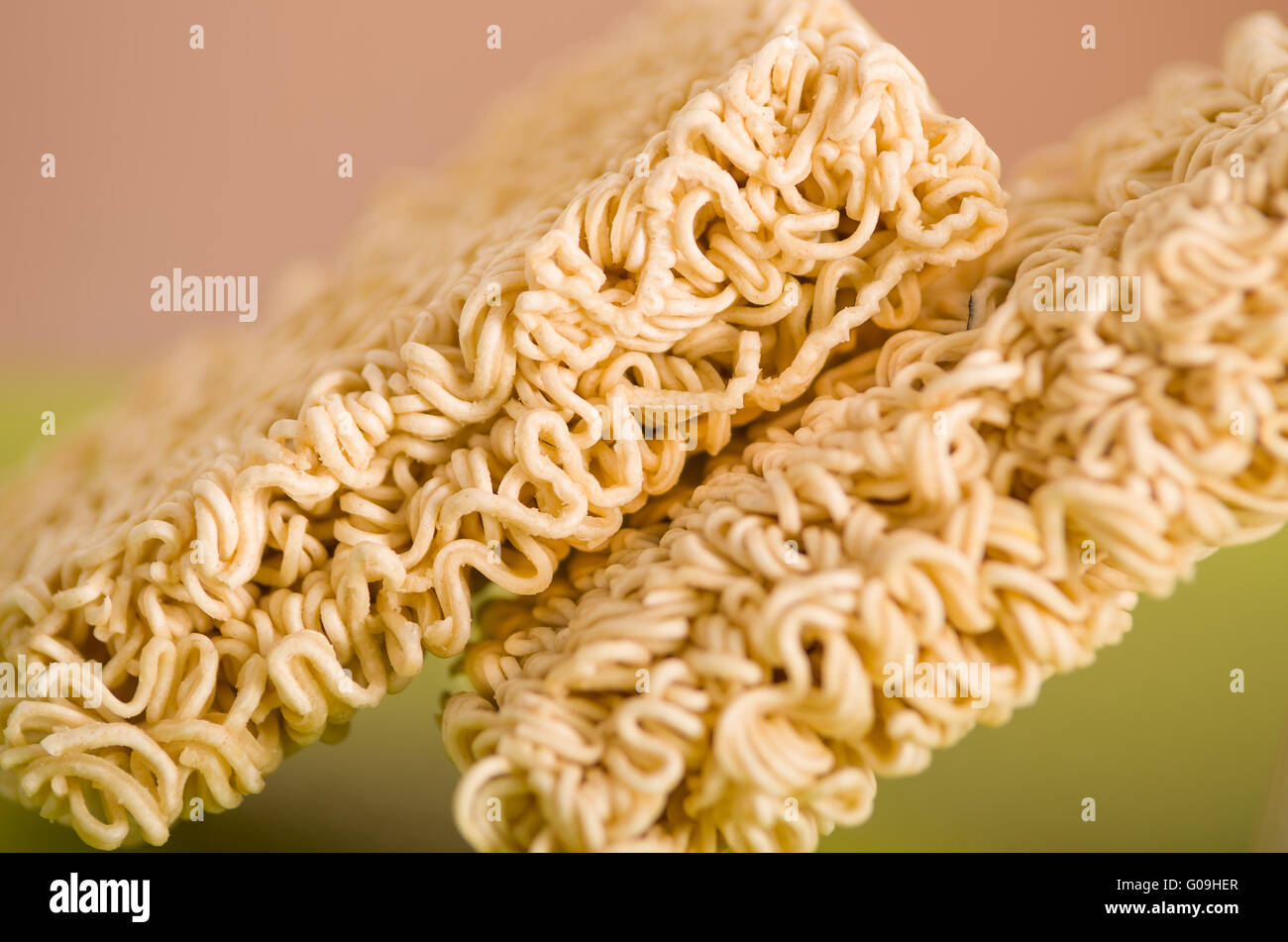 Closeup uncoked noodle blocks with blurry background Stock Photo - Alamy