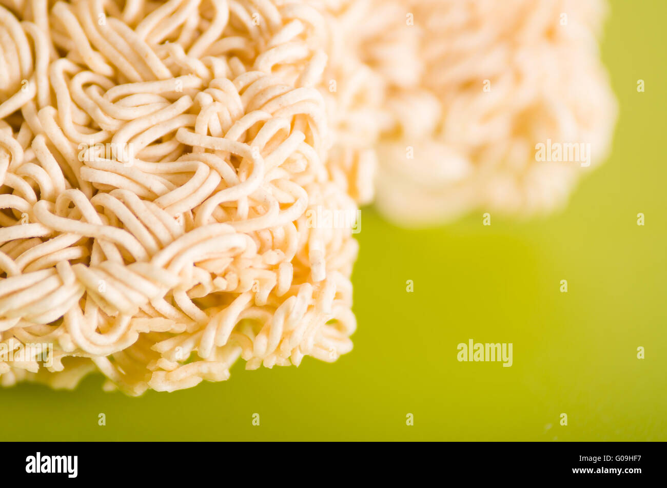 Closeup uncoked noodle block with blurry background Stock Photo - Alamy