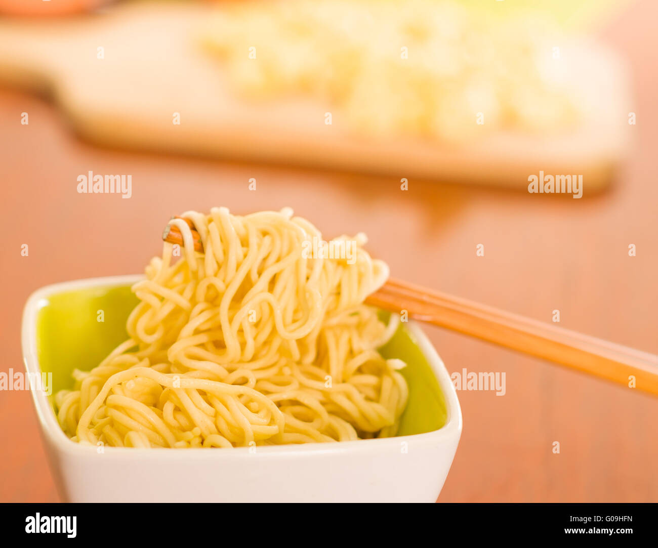 Elegant presentation of cooked noodles inside small square bowl sitting ...