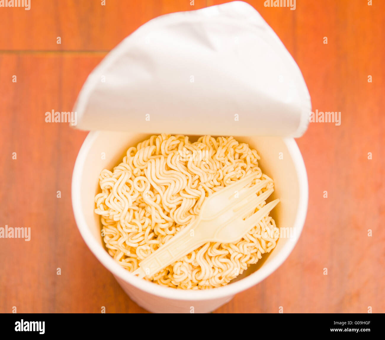 Box of newly opened noodle box, still uncooked with plastic spoon lying ...