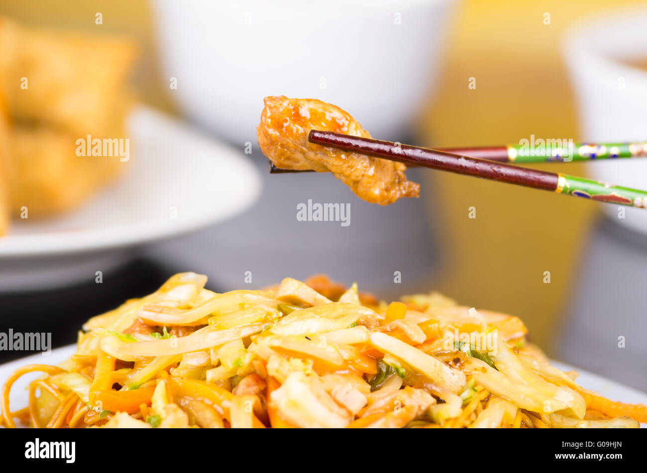 Two refined chopsticks are hanging a piece of chicken Stock Photo - Alamy