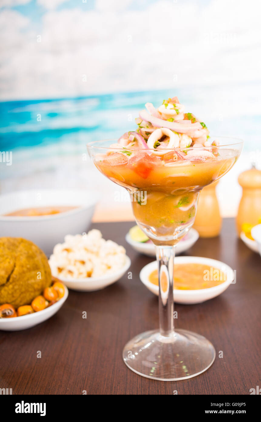 Squid delicious ceviche on wooden table, behind traditional ecuadorian ...