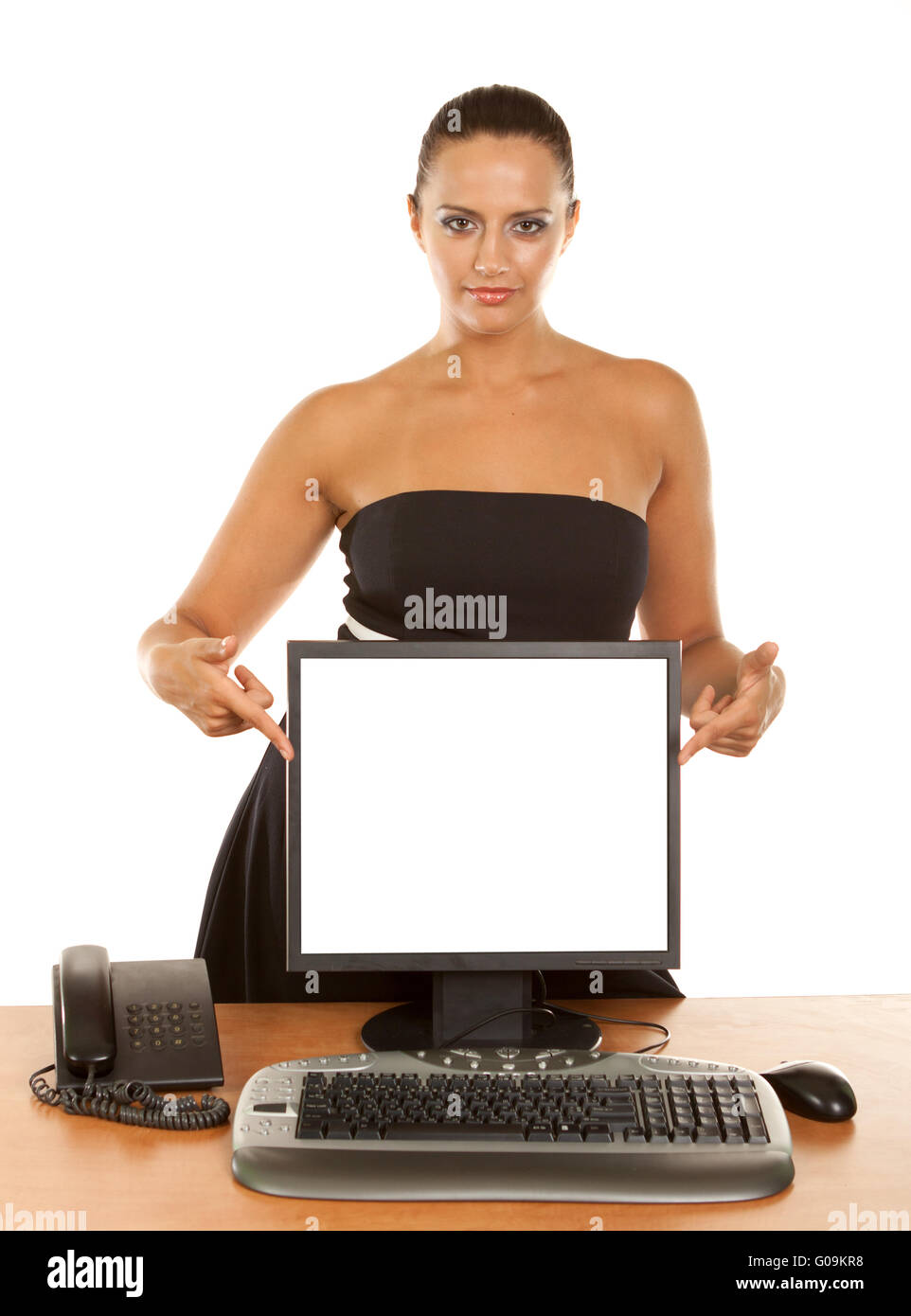 Pretty business woman at office desk pointing at a computer isolated a ...