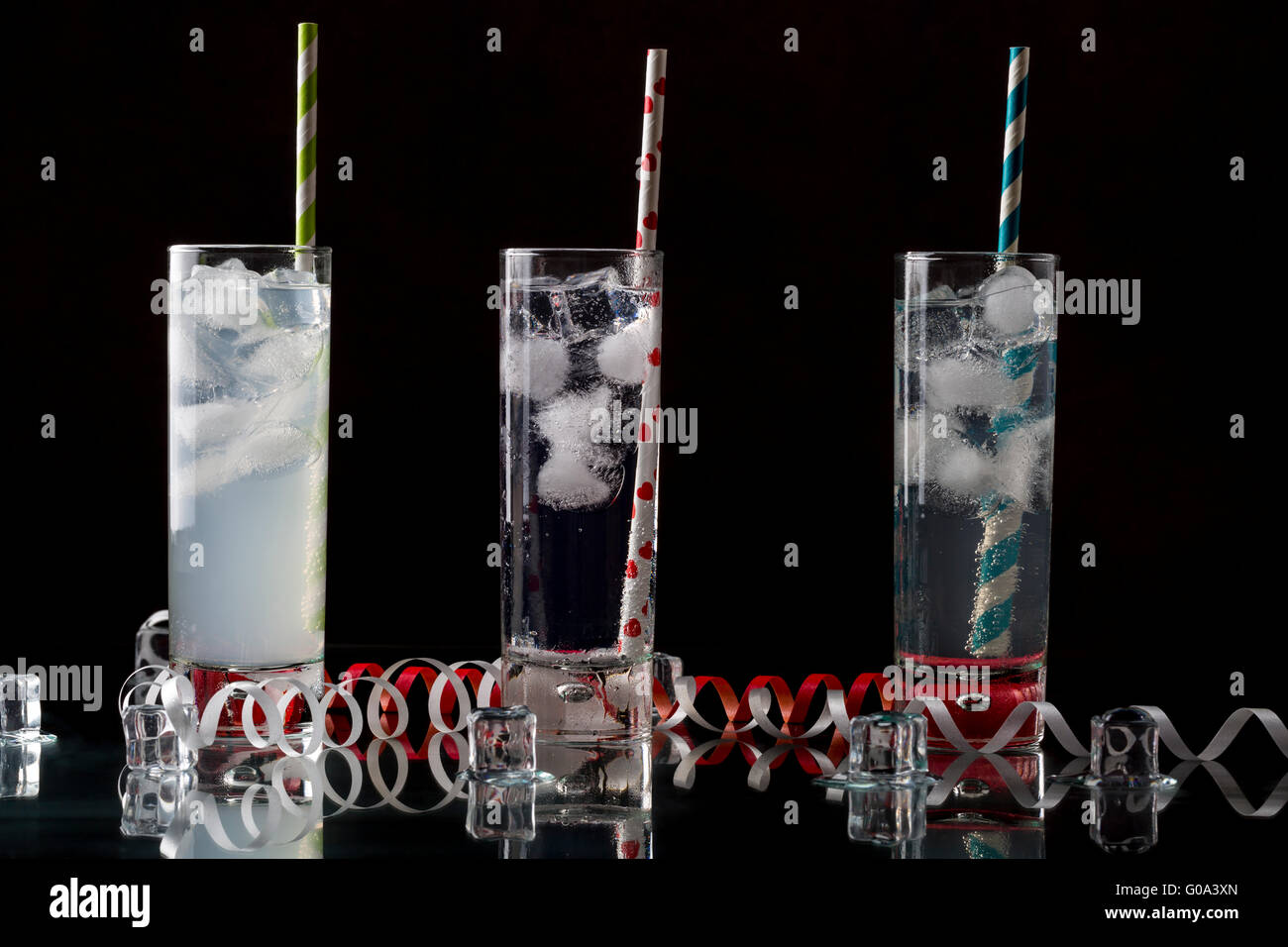 Set from three a collins glass with cocktails and colored straws ...