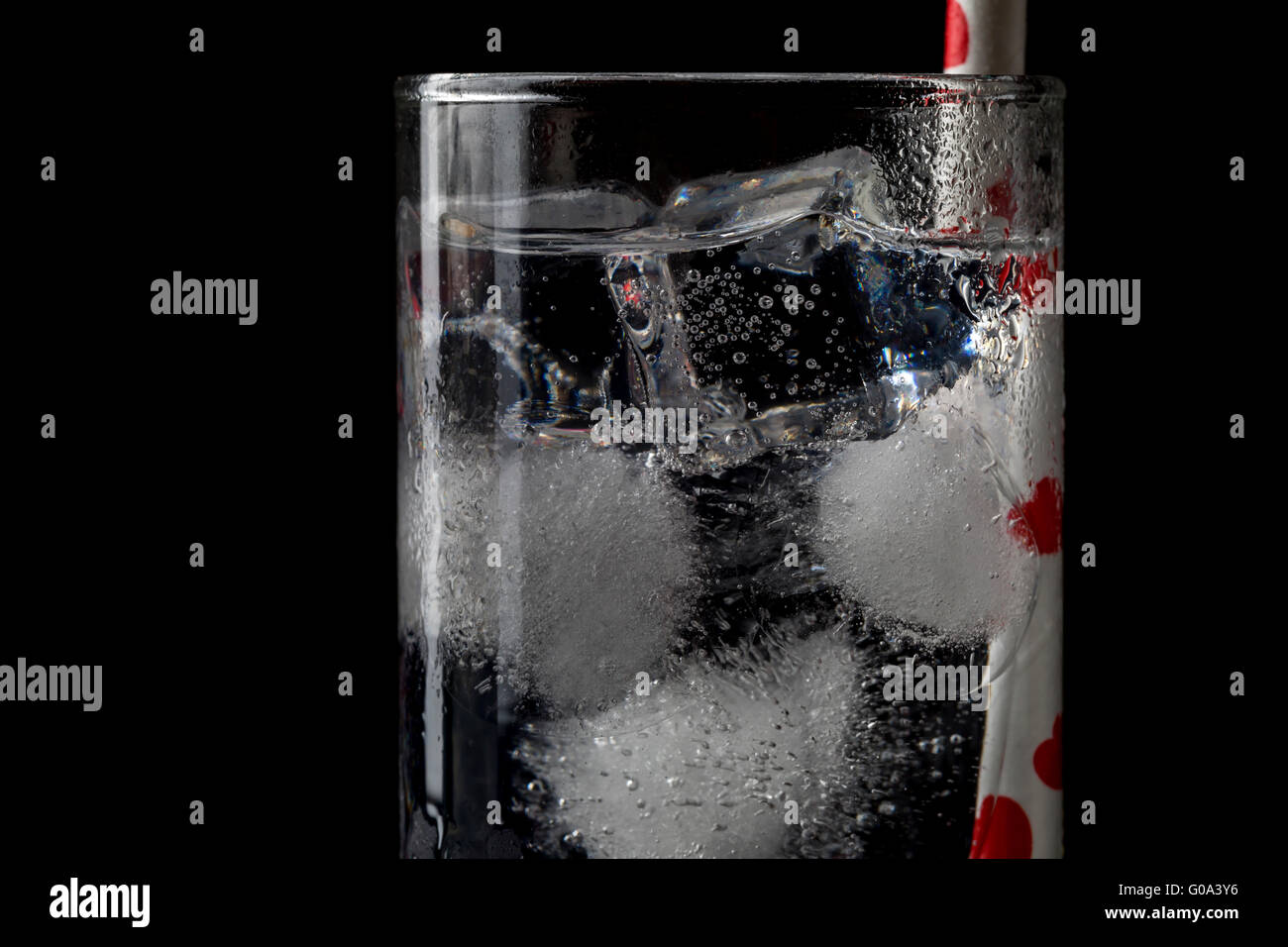 Collins glass with cocktails and colored straws. Decorated melted ice ...