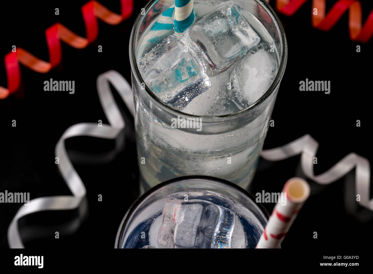 Set from two a collins glass with cocktails and colored straws ...