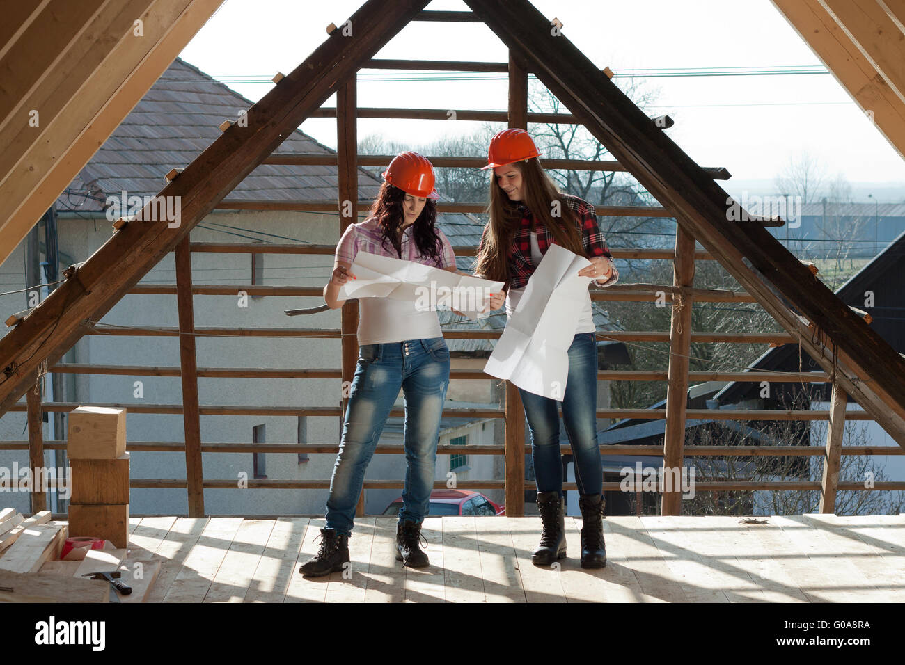 Two young women workers on the roof Stock Photo - Alamy
