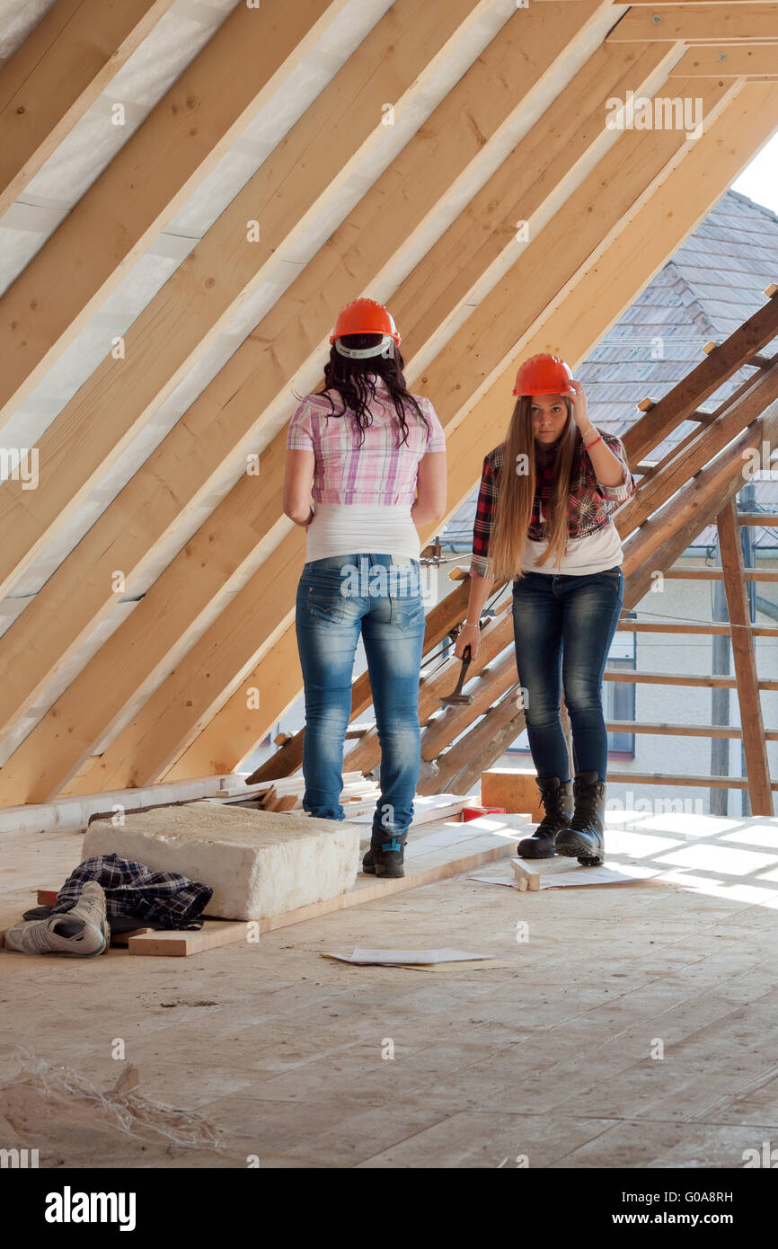 Two young woman repairing the roof of the house Stock Photo - Alamy