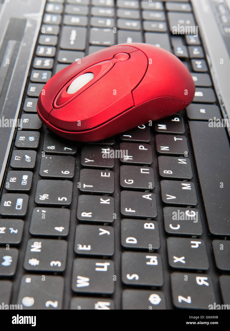 The red computer mouse on the black keyboard Stock Photo - Alamy