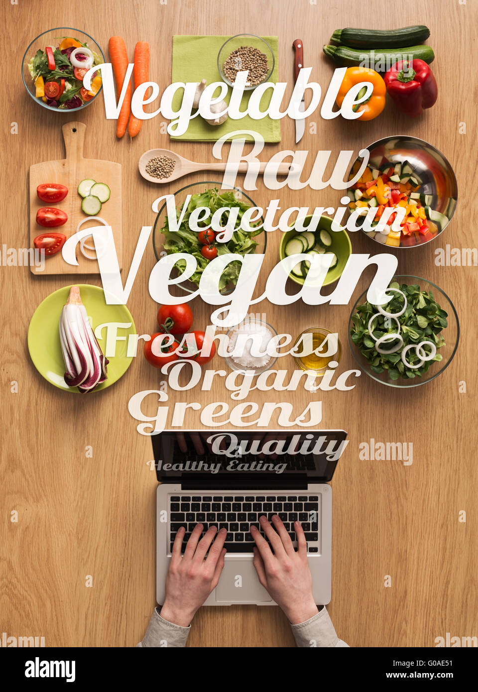 Hands typing on a laptop with fresh vegetables and healthy eating text ...